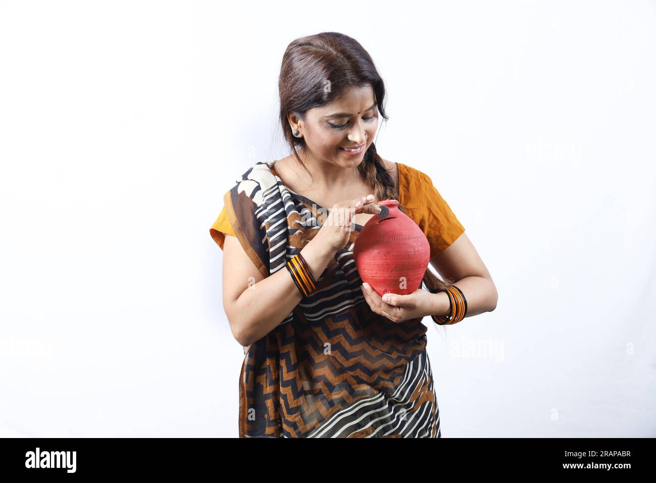 Happy rural Indian old lady in saree standing in white background ...