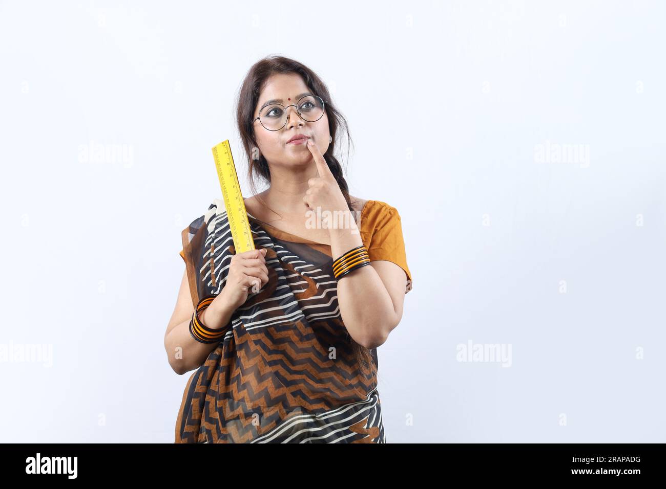 Rural Indian happy woman teacher in village holding yellow scale ...