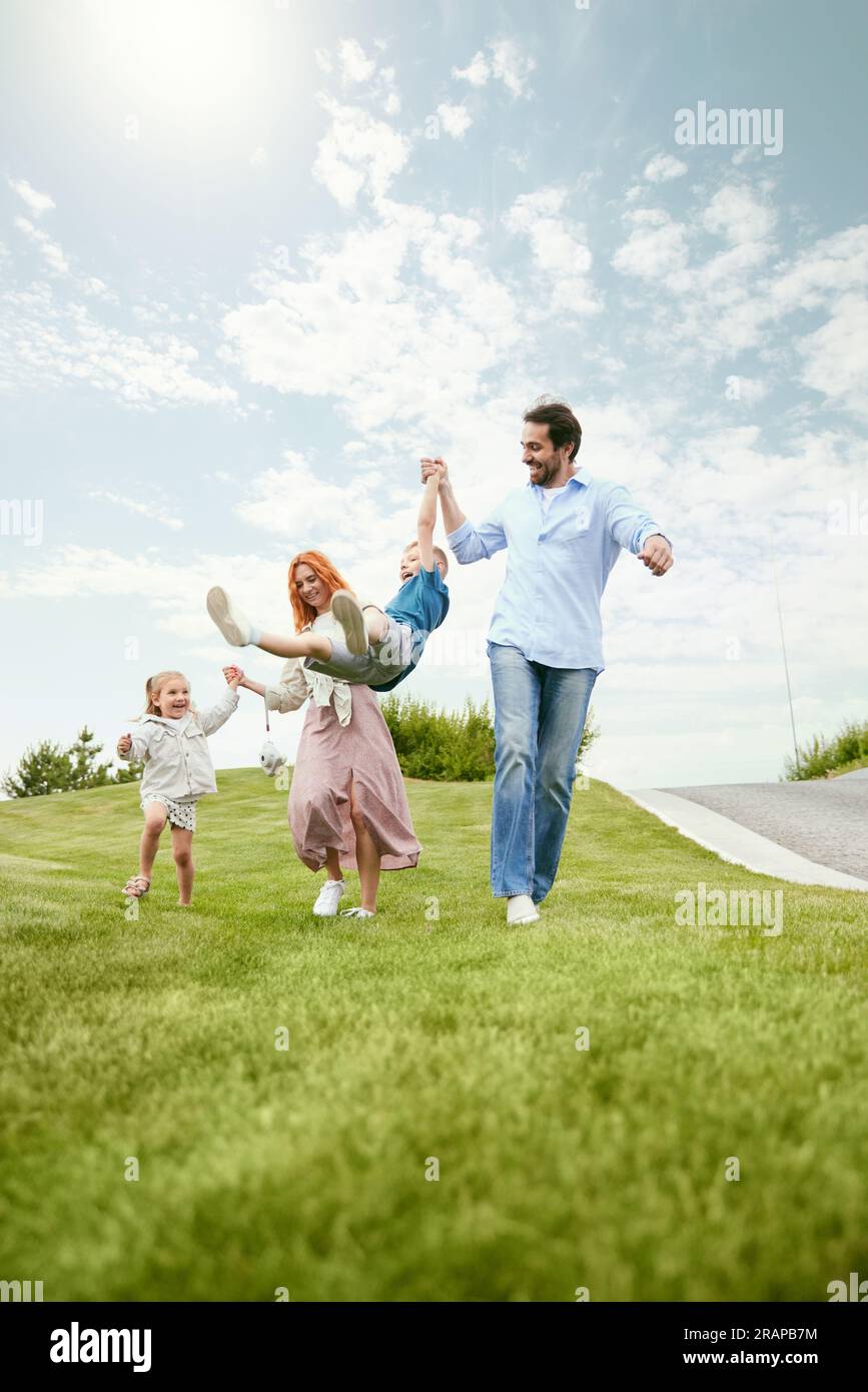Young joyful couple, man and woman going for a walk in park with their ...