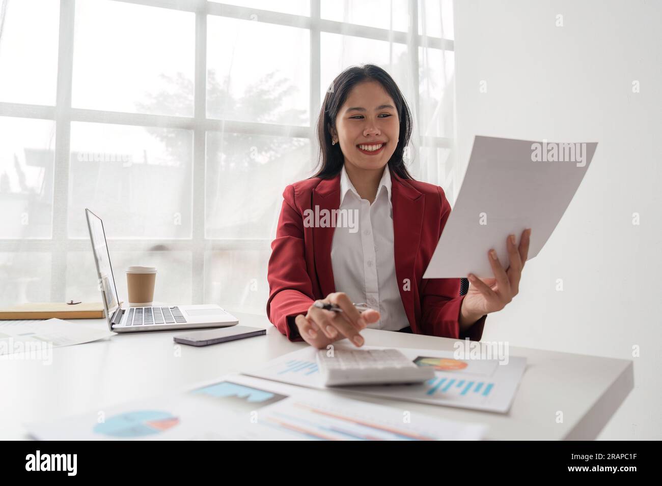 Asian business woman using a calculator calculating financial expense ...