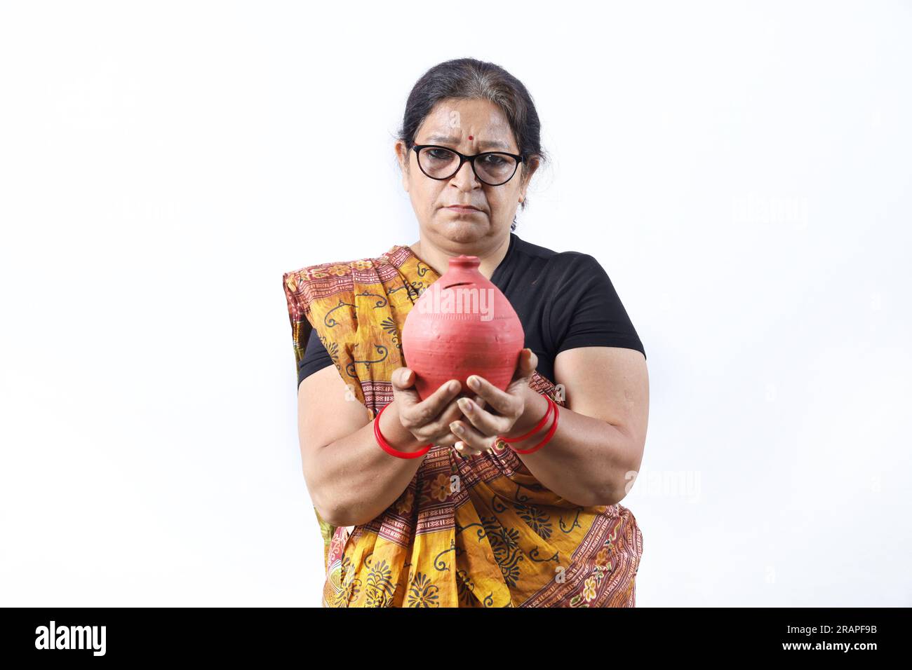 Happy rural Indian old lady in saree standing in white background ...