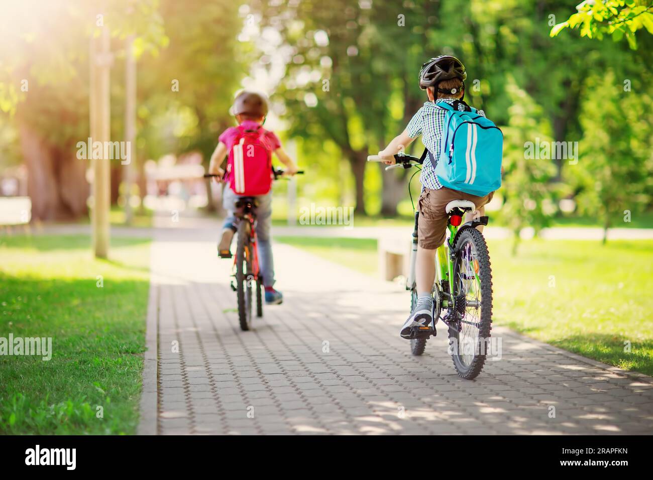 Two boys with backpacks on bicycles going to school Stock Photo - Alamy