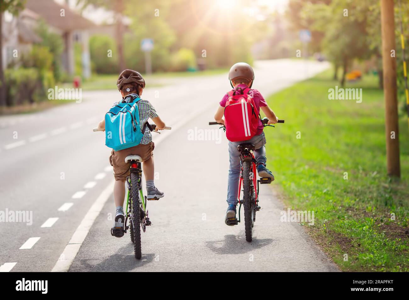 Two boys with backpacks on bicycles going to school Stock Photo - Alamy