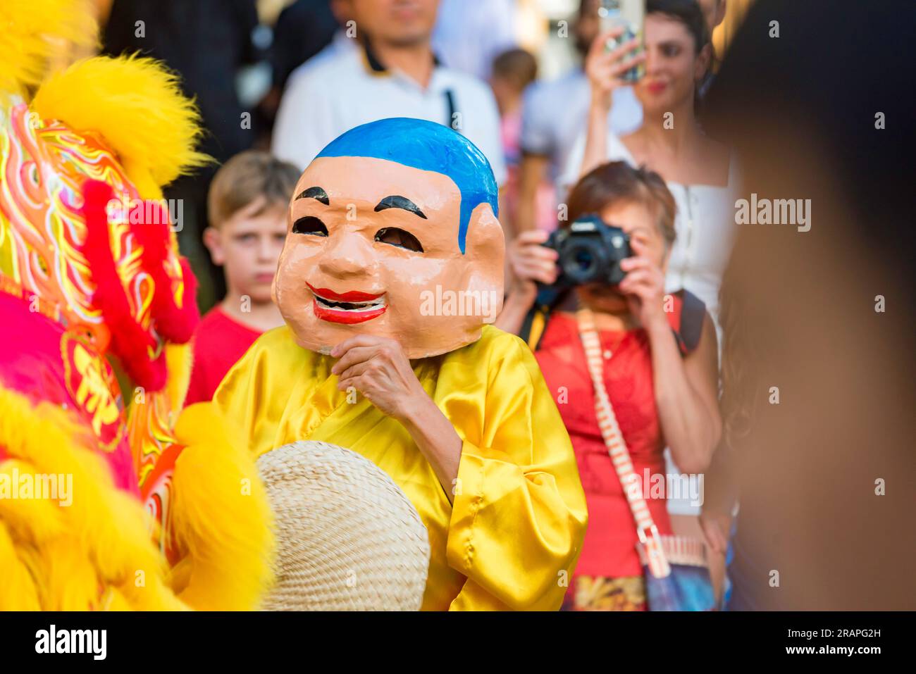 A happy Buddha and a Chinese Dragon moving through a crowd during Lunar ...