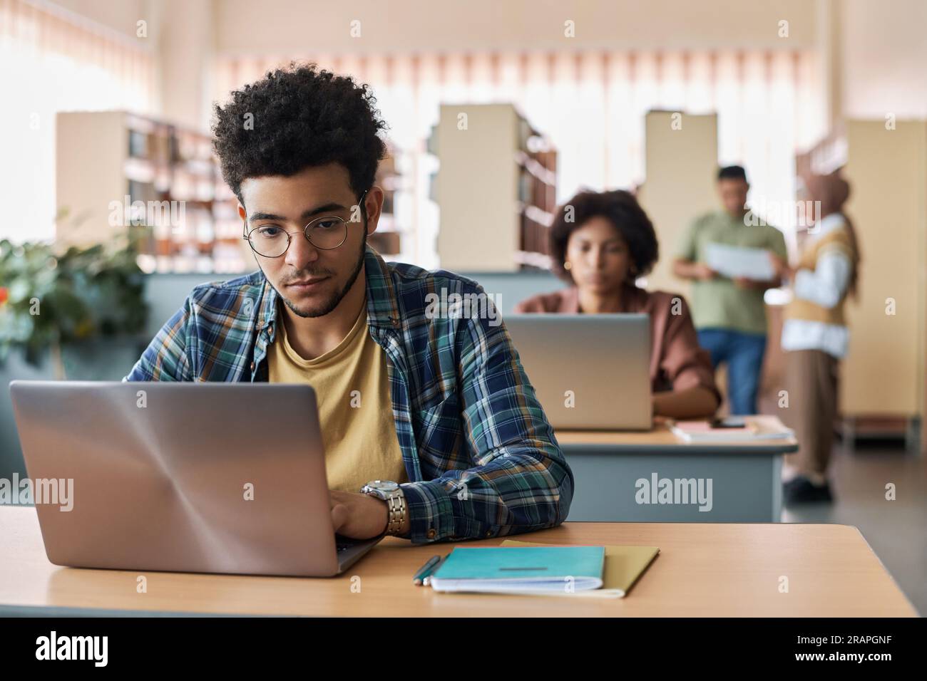 Adult student sitting at his desk and concentrating on his online work ...