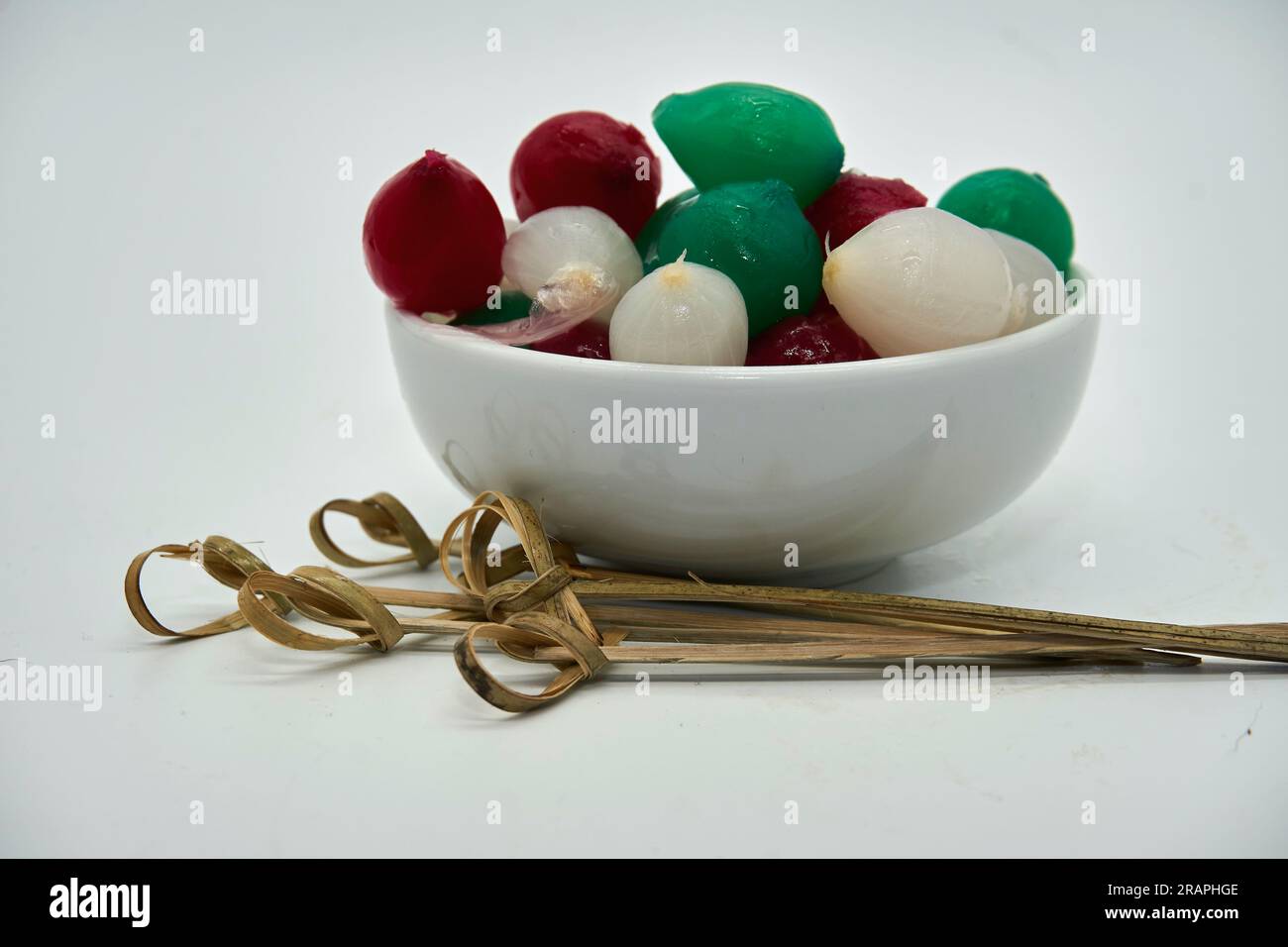 A bowl of Coloured Pickled Cocktail onions with bamboo skewers Stock ...