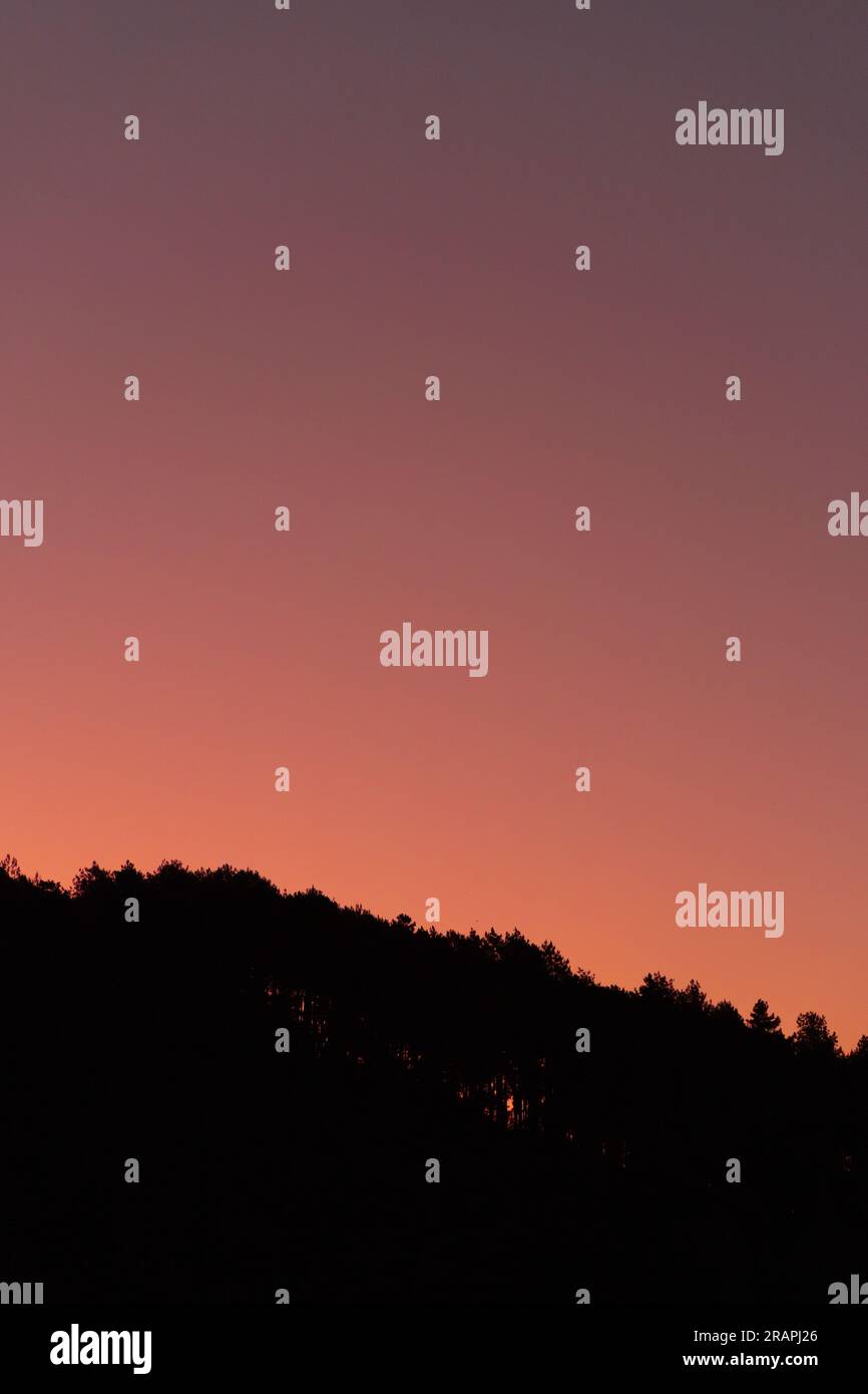 Dark silhouette of hills on pink sunrise view. Sundown landscape with ...