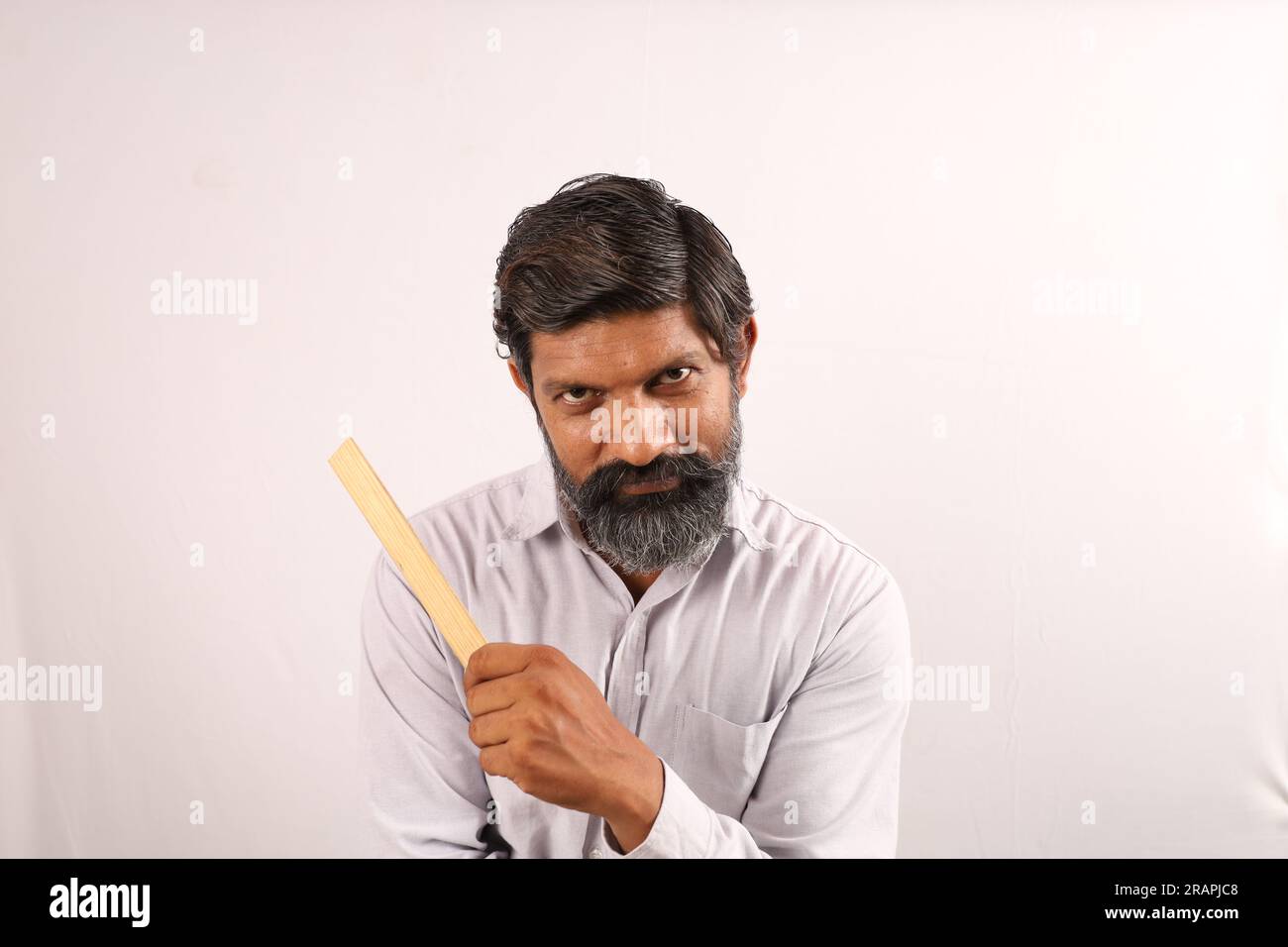 Portrait of an Indian bearded man in anger wearing shirt holding a ...