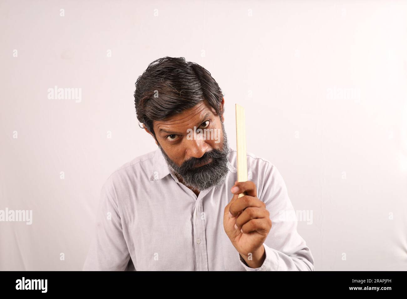 Portrait of an Indian bearded man in anger wearing shirt holding a ...