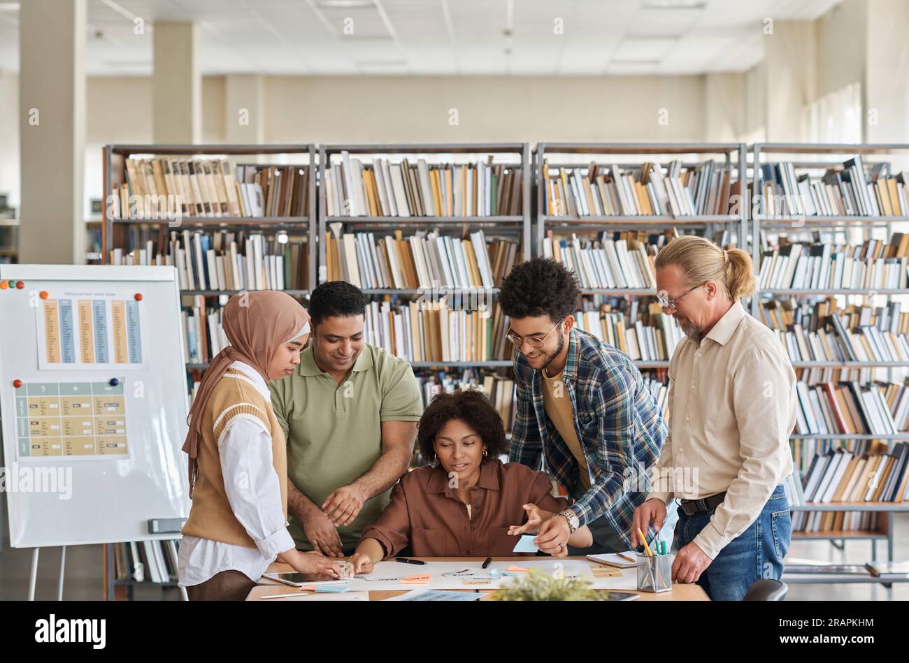 Group of students working in team with teacher, they learning English ...