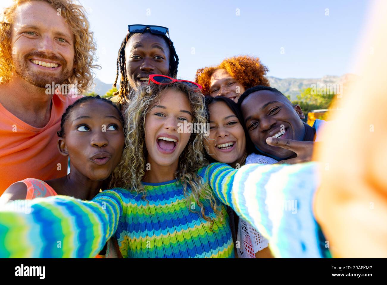 Happy diverse group of friends having party, taking a selfie in garden ...