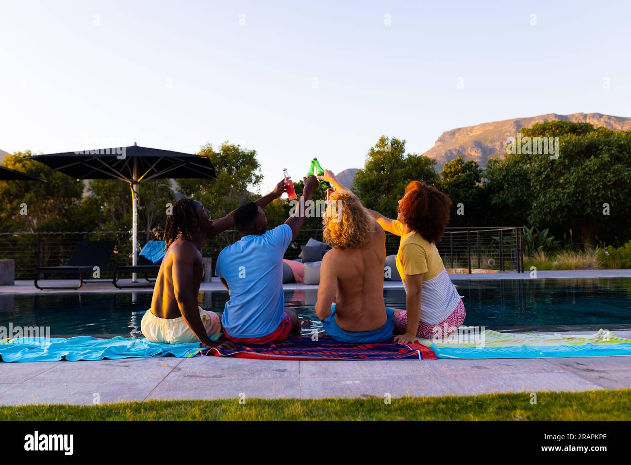 Happy diverse group of friends having pool party drinking beer and ...