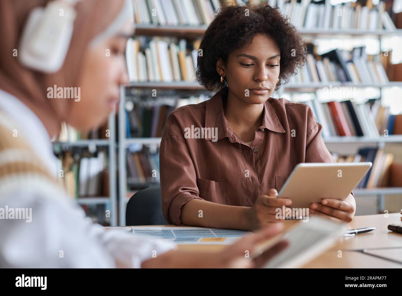 African American student watching online lesson on tablet pc while ...