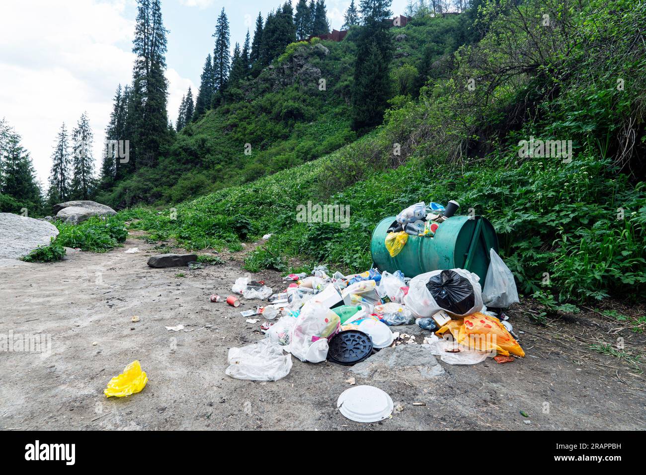 Mountain of plastic debris under a tree in a park or forest. Pollution ...