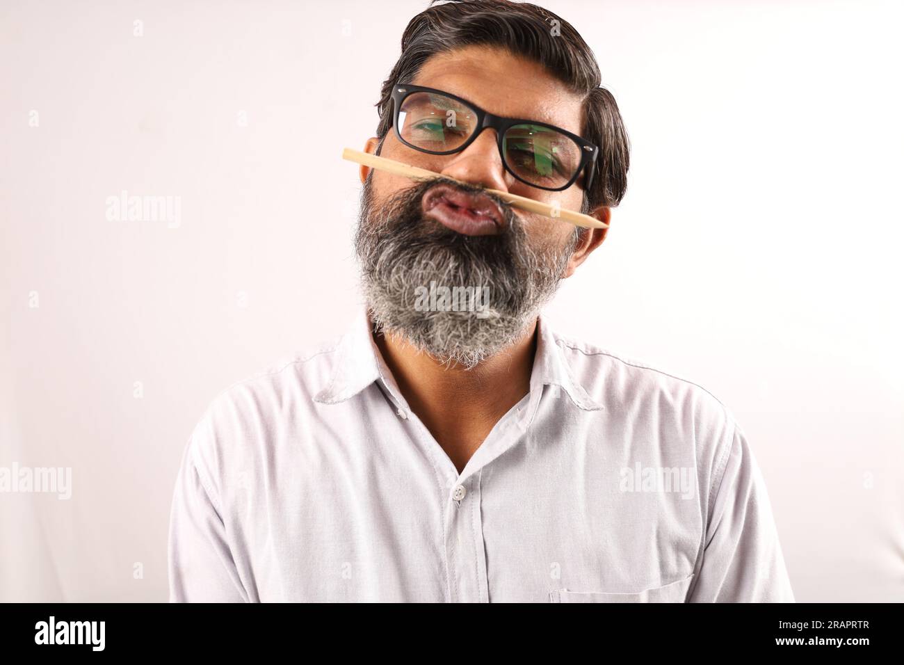 Portrait of an Indian bearded man in anger wearing shirt holding a ...