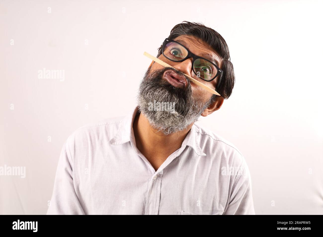 Portrait of an Indian bearded man in anger wearing shirt holding a ...