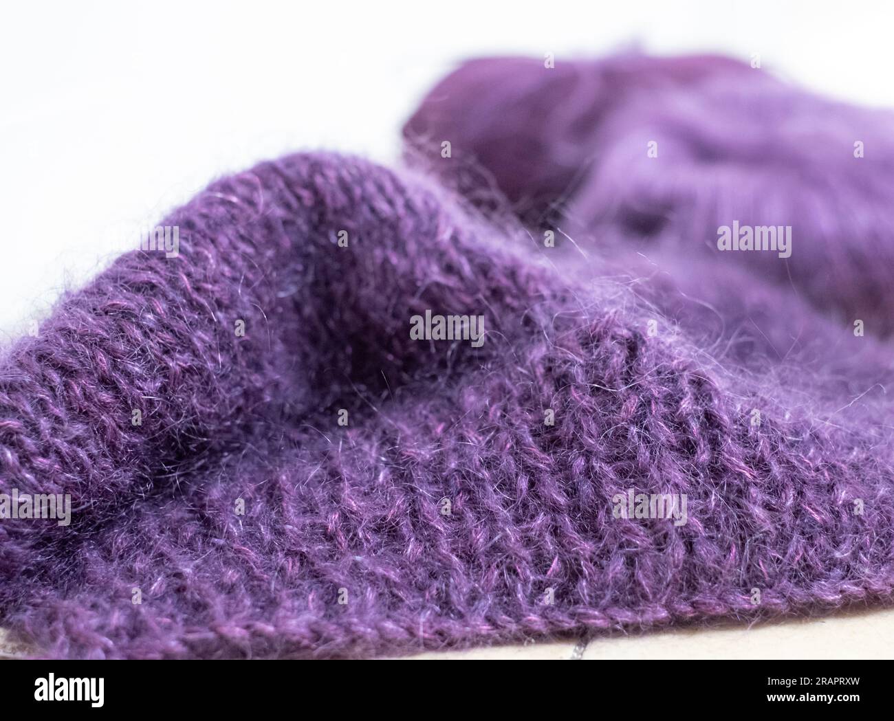 Close up of purple mohair and alpaca yarn hand knitted sweater with ...