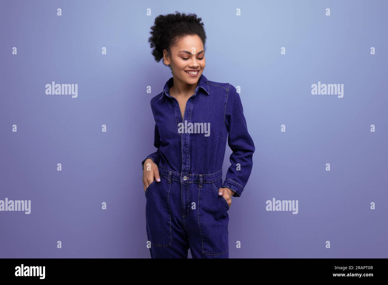 a young woman with dark skin and black hair is dressed in a blue genim ...