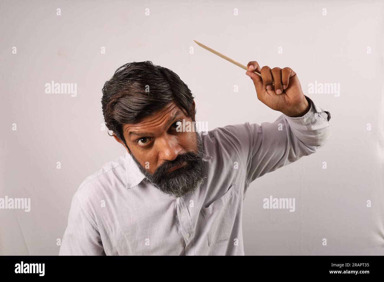 Portrait of an Indian bearded man in anger wearing shirt holding a ...
