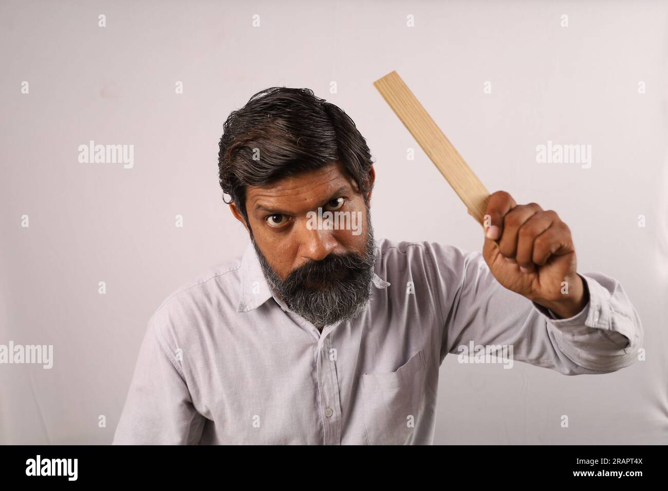 Portrait of an Indian bearded man in anger wearing shirt holding a ...