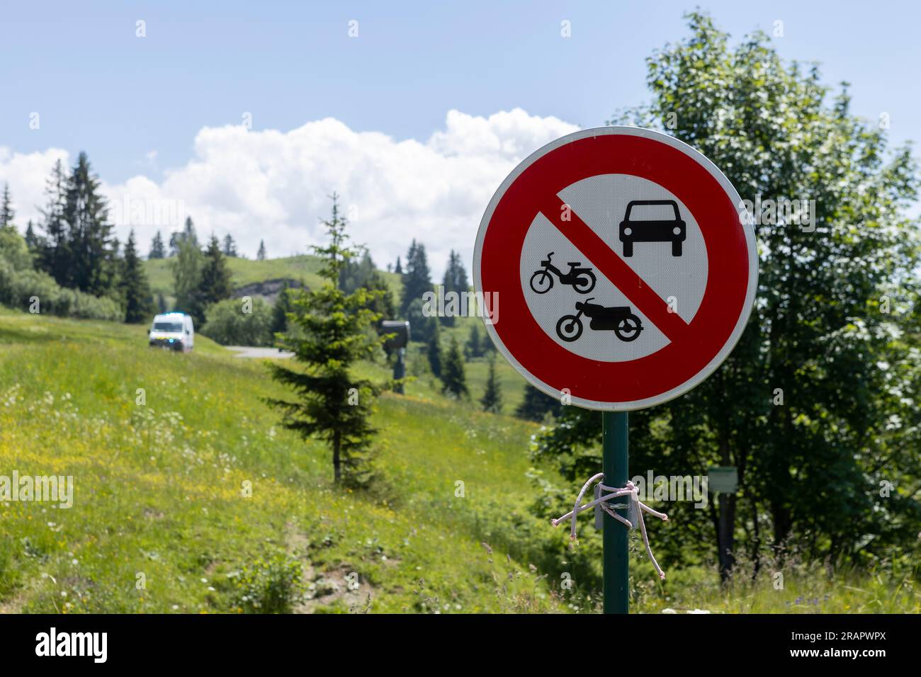 No entry sign in mountainous area with in the background a car passing ...
