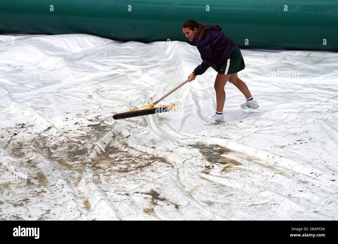 Rain water is cleared from the court covers on the practice courts on ...