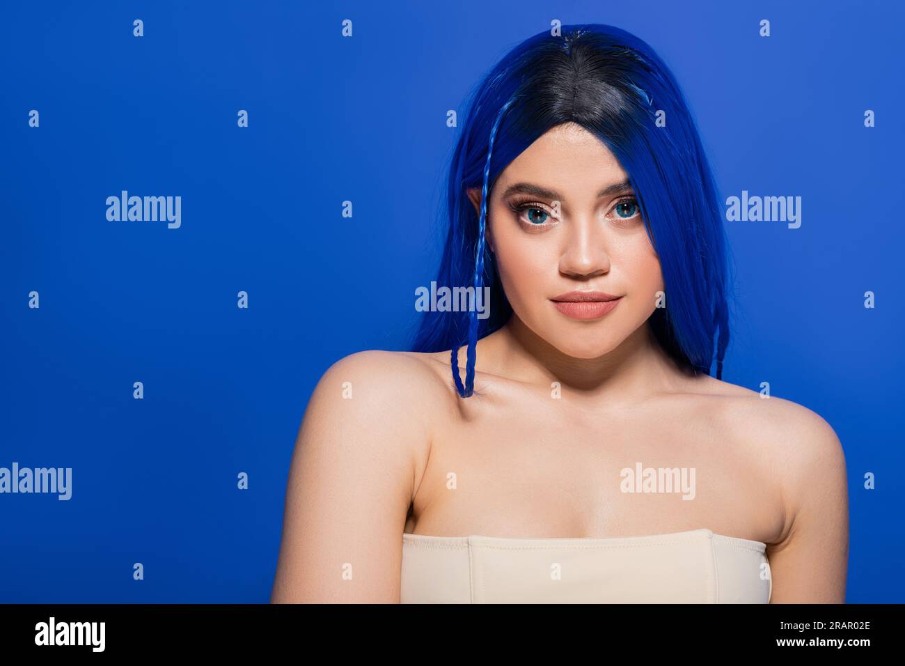 modern beauty concept, young woman with dyed hair posing on blue ...