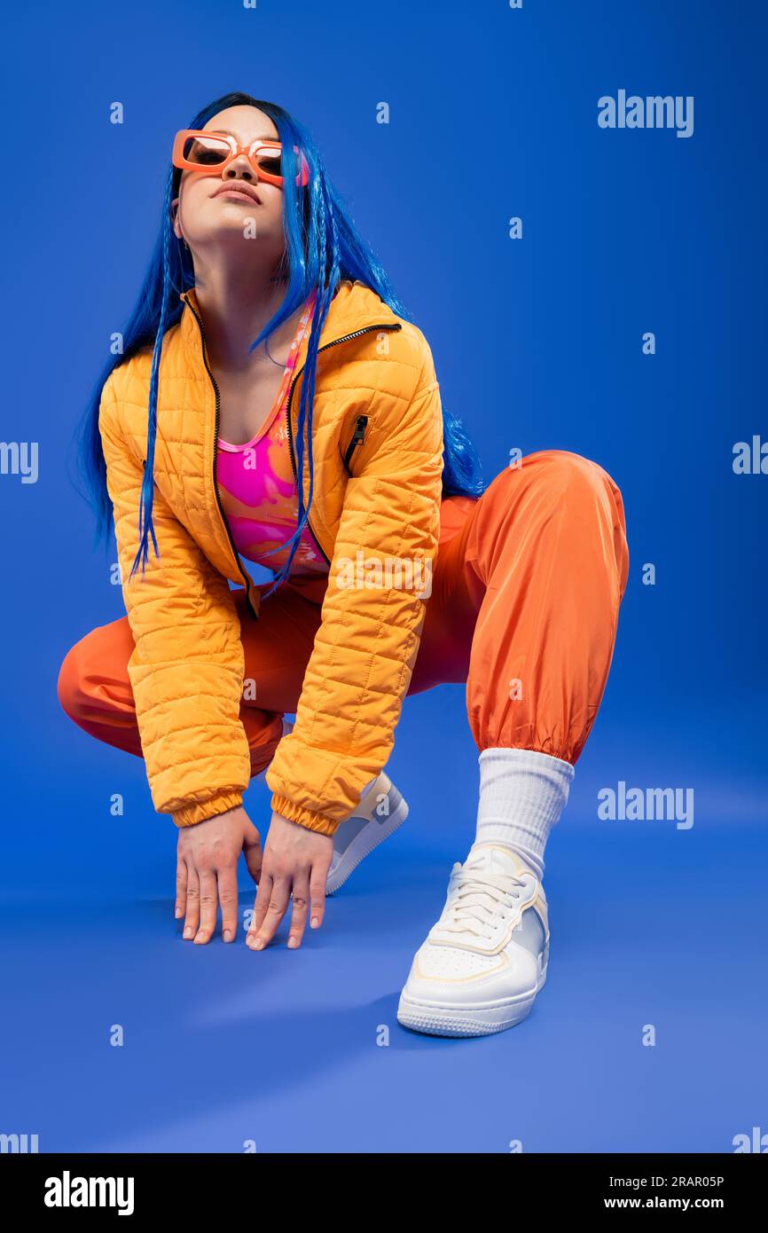 full length of young female model with blue hair and trendy sunglasses ...