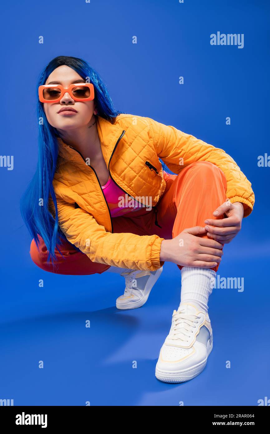 full length of pretty young female model with blue hair and trendy ...