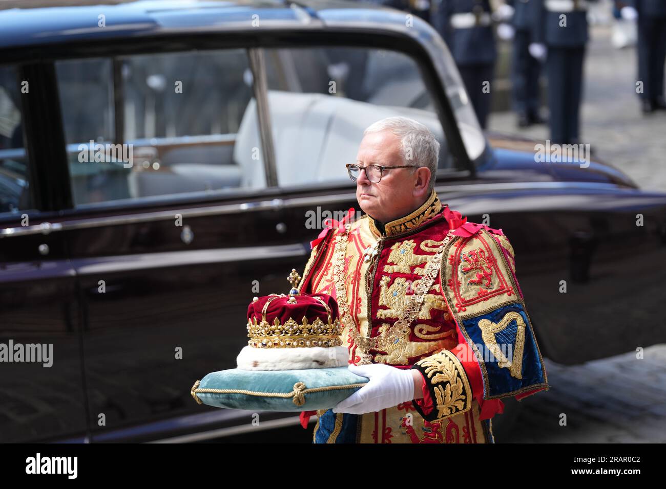 Lord Lyon King of Arms Joseph Morrow carrying the Crown, which forms ...