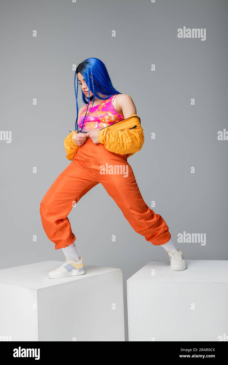 full length, fashion forward, young woman with blue hair posing in ...