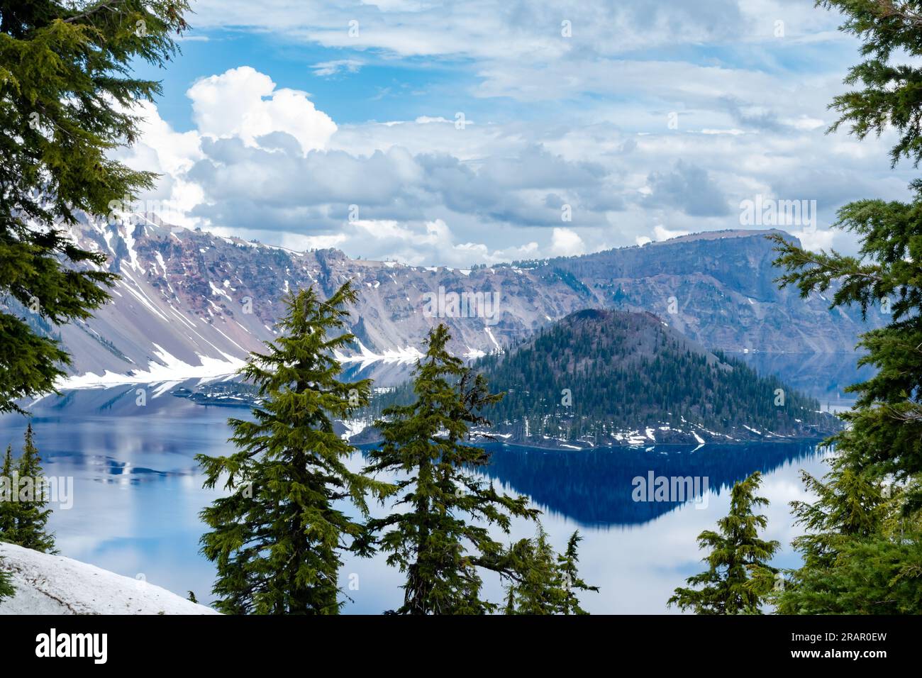 View through the pine trees into the deep blue waters of the Caldera of ...