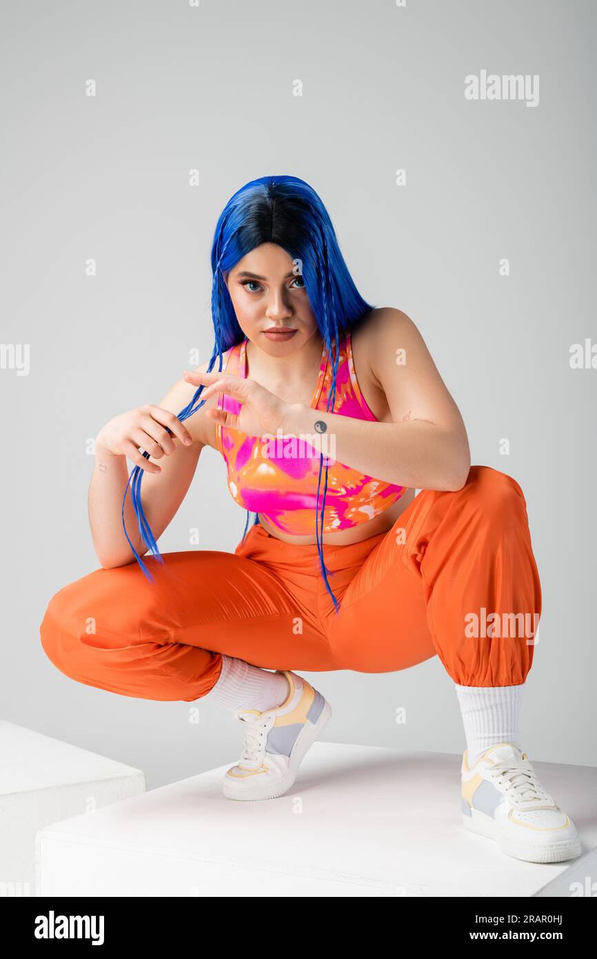 youth culture, tattooed young woman with blue hair sitting on top of ...