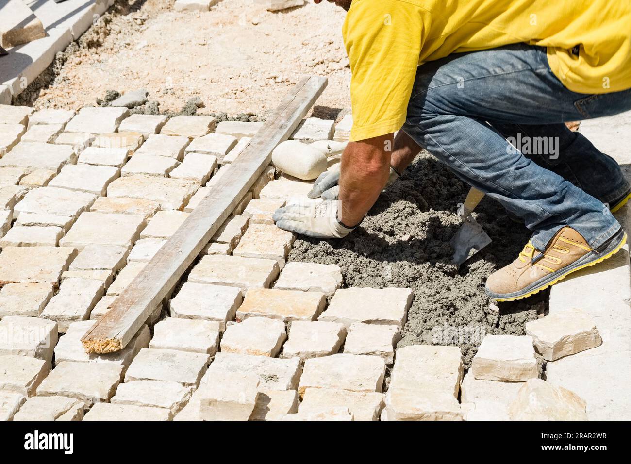 Real scene of a worker working on a classic style walkway pavement with ...