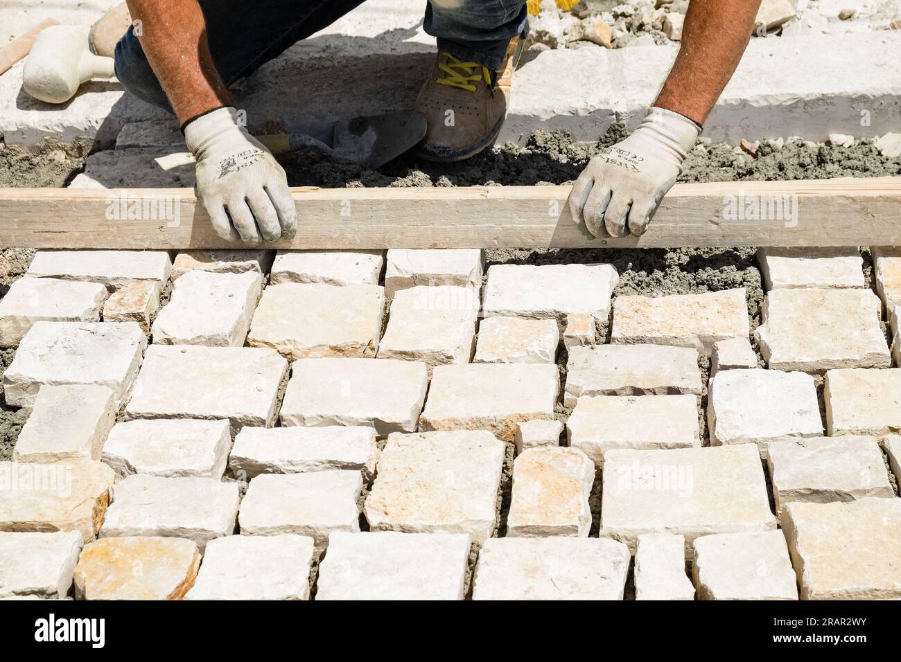 Real life scene of a worker lining up the bricks of a traditional ...