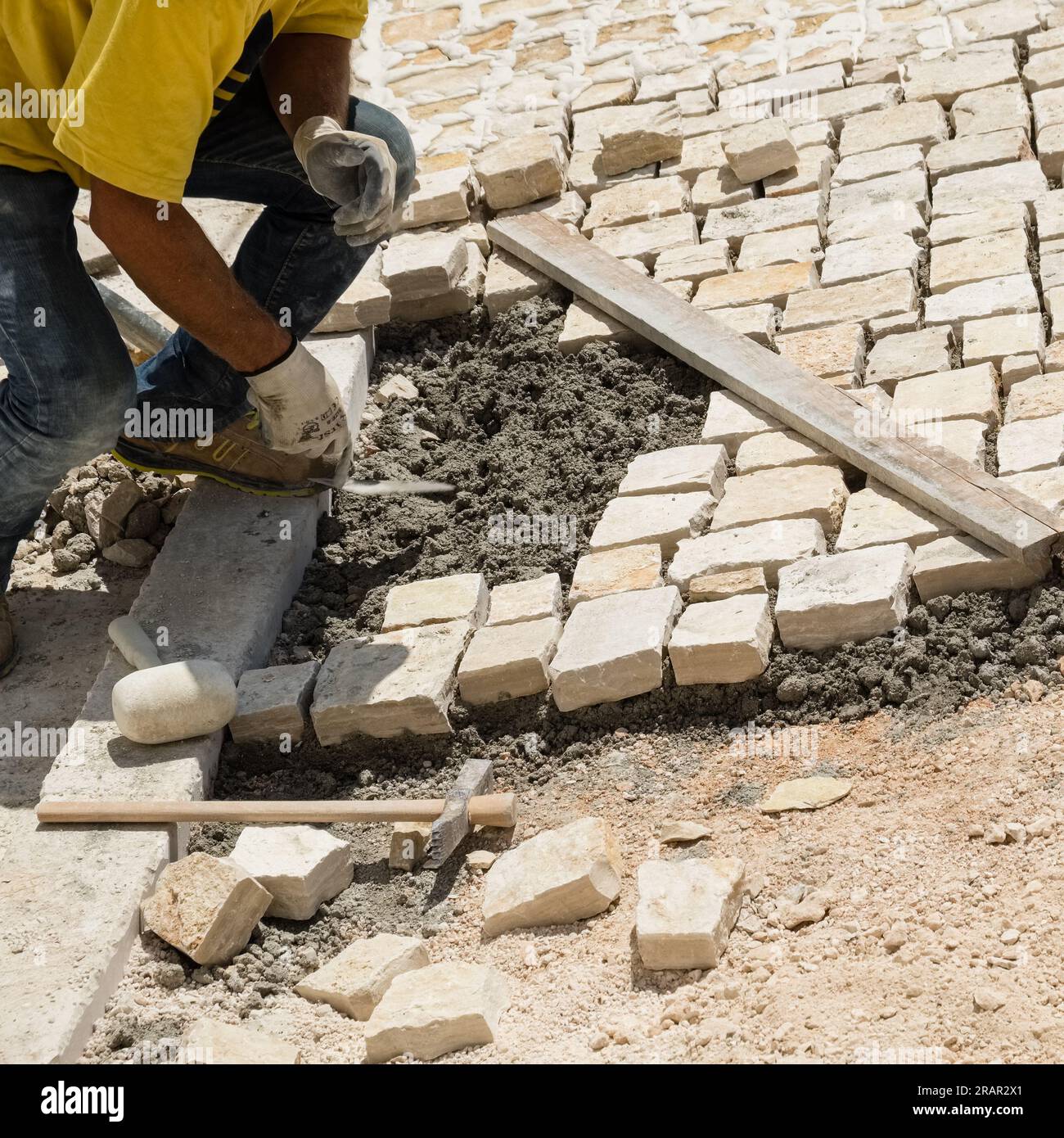 Real scene of a worker working on a classic style walkway pavement with ...