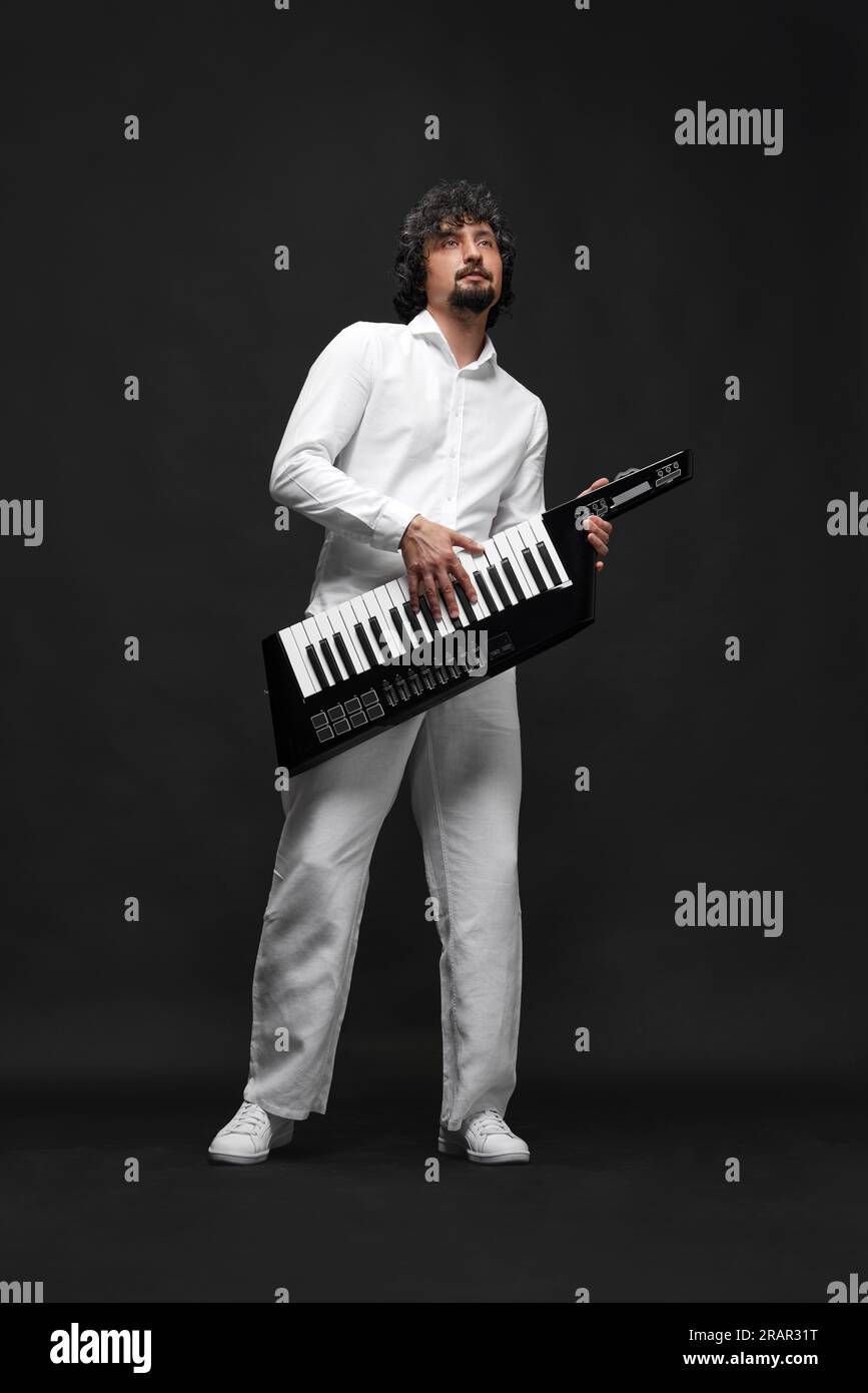 Full-length image of stylish bearded man in white suit playing ...