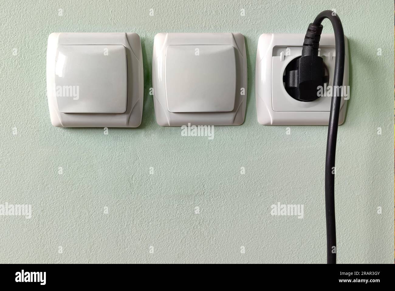 Group of white european electrical outlets with plug inserted into it ...