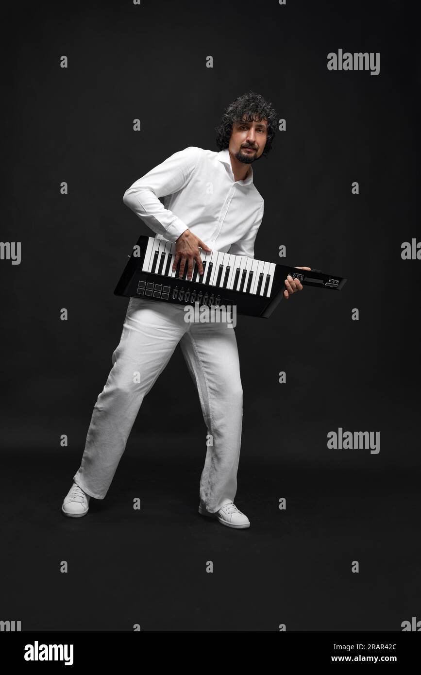 Full-length image of stylish bearded man in white suit playing ...