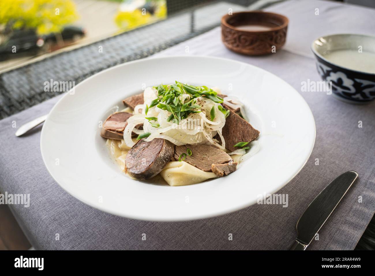 Composition of tasty Kazakh national dish beshbarmak in a plate with ...