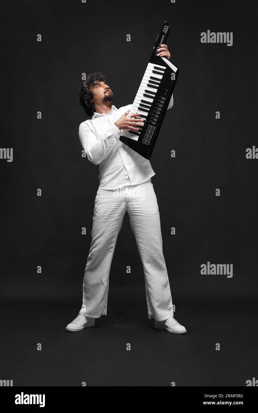 Full-length image of stylish bearded man in white suit playing ...
