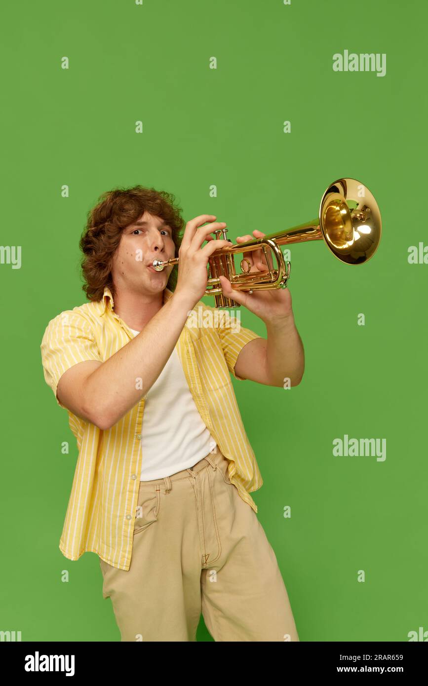 Portrait of young man with curly hair, talented musician playing ...