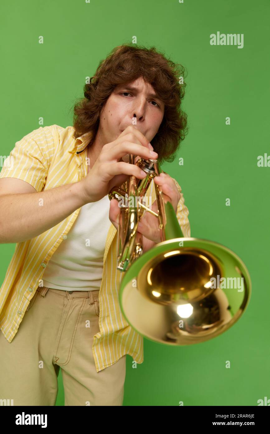 Portrait of young man with curly hair, talented musician playing ...