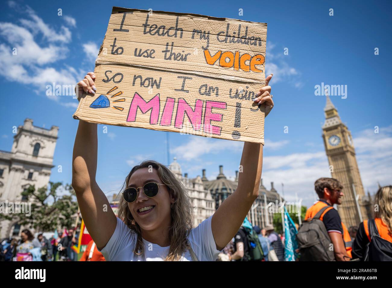 London, UK. 5 July 2023. A striking teacher holds up a sign during a ...