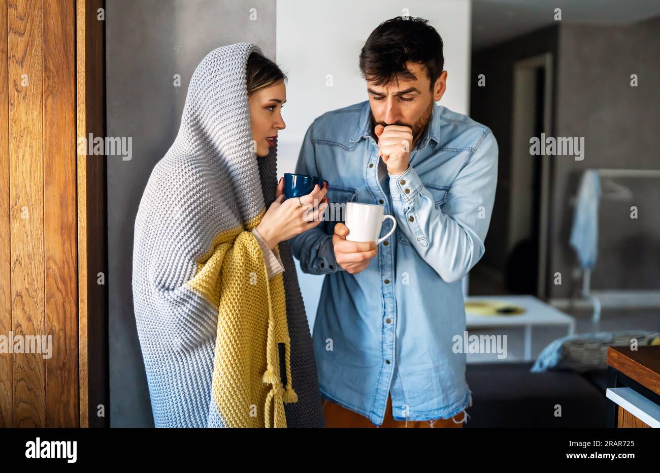 Freezing couple covered with a blanket. Man and a woman wrapped in a ...