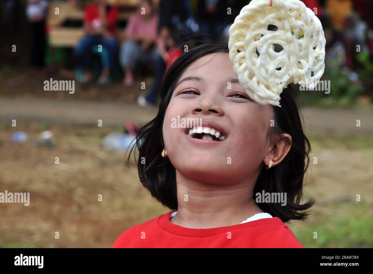 West Java, Indonesia - August 17, 2022: Little child are following the race eating crackers in ...