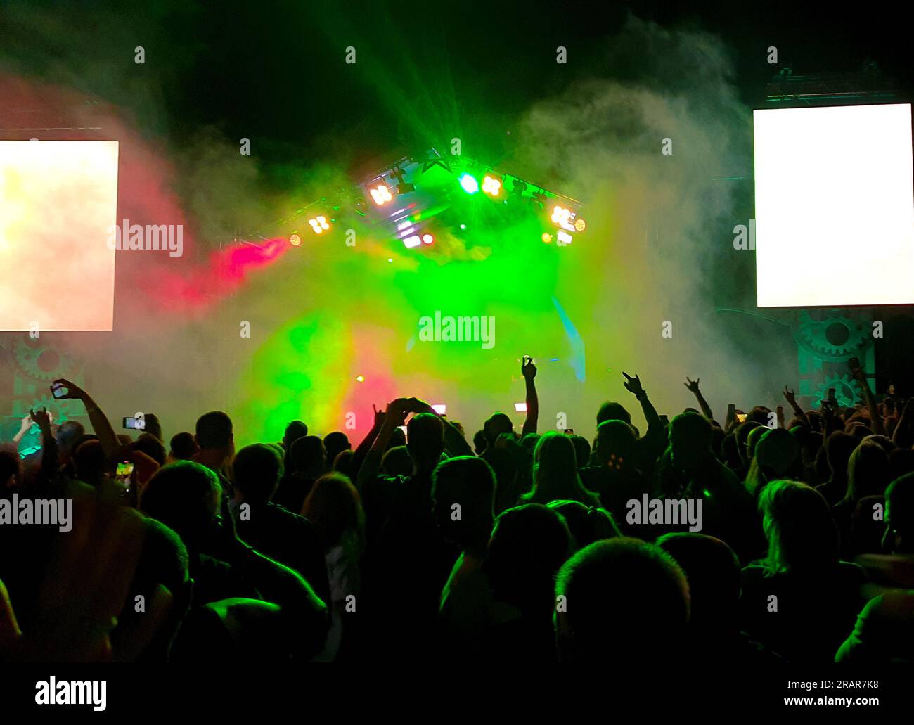 A crowd of fans at a concert under the spotlight. . A scene with ...