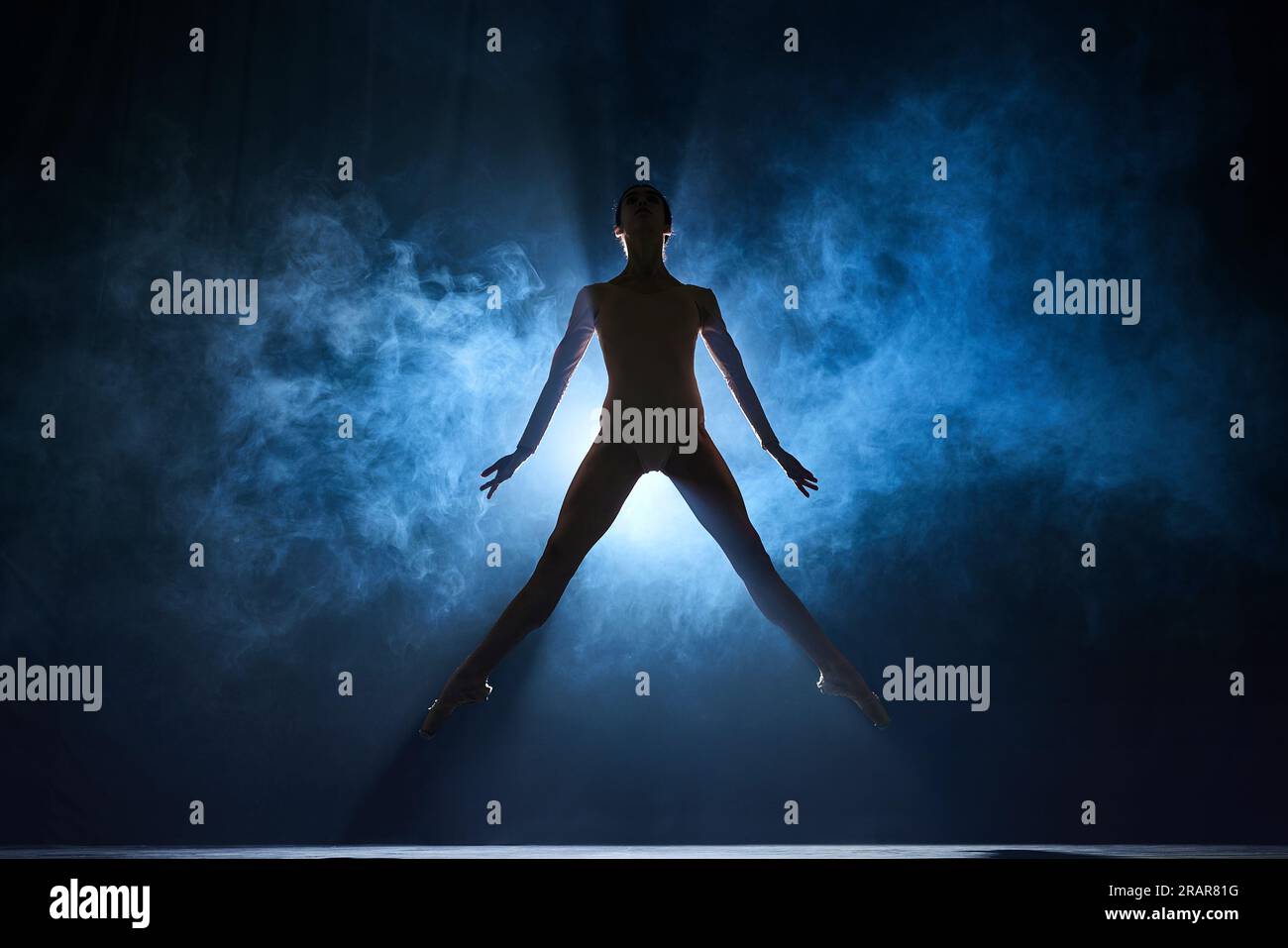 Elegant femininity. Beautiful, tender young woman, ballerina dancing against dark blue ...