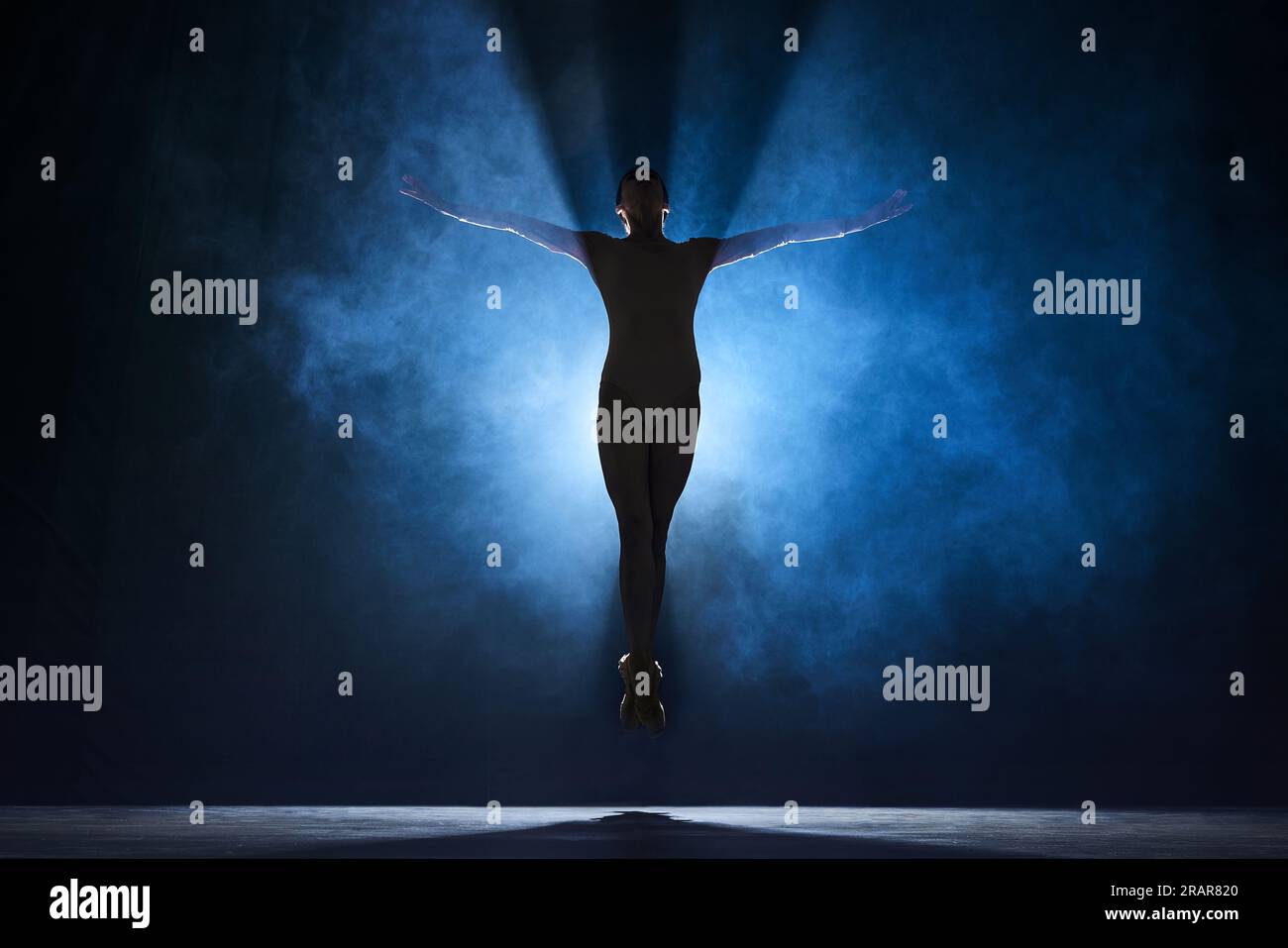 Elegant femininity. Beautiful, tender young woman, ballerina dancing against dark blue ...