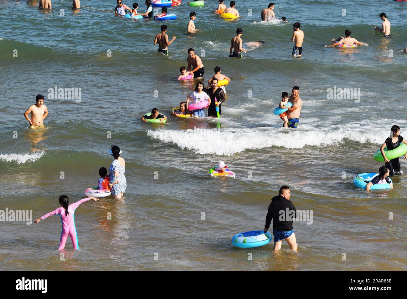 QINGDAO, CHINA - JULY 5, 2023 - Tourists swim in the sea to escape the ...
